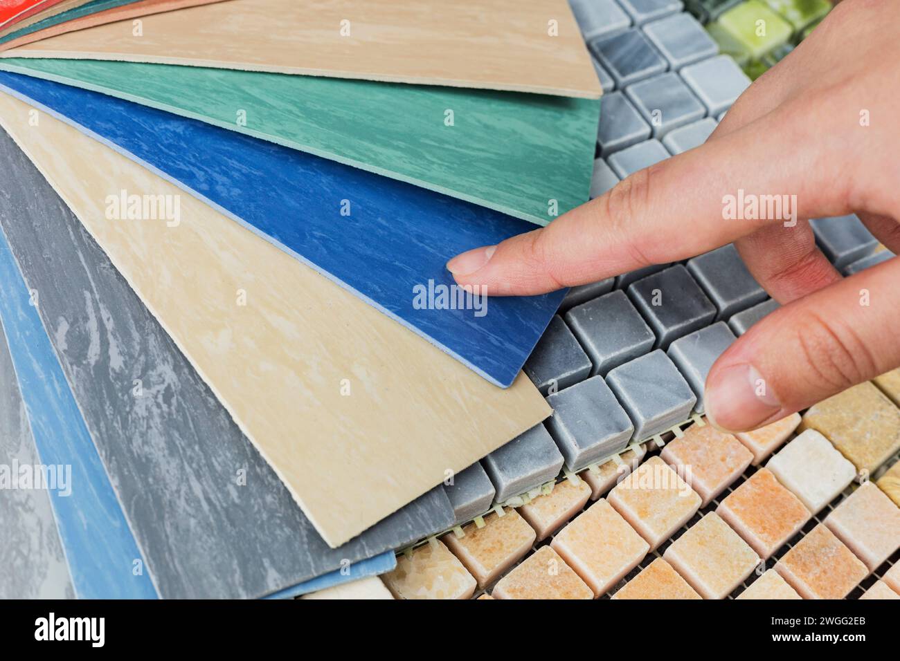 designer's hand choosing samples of interior stone material consists ...