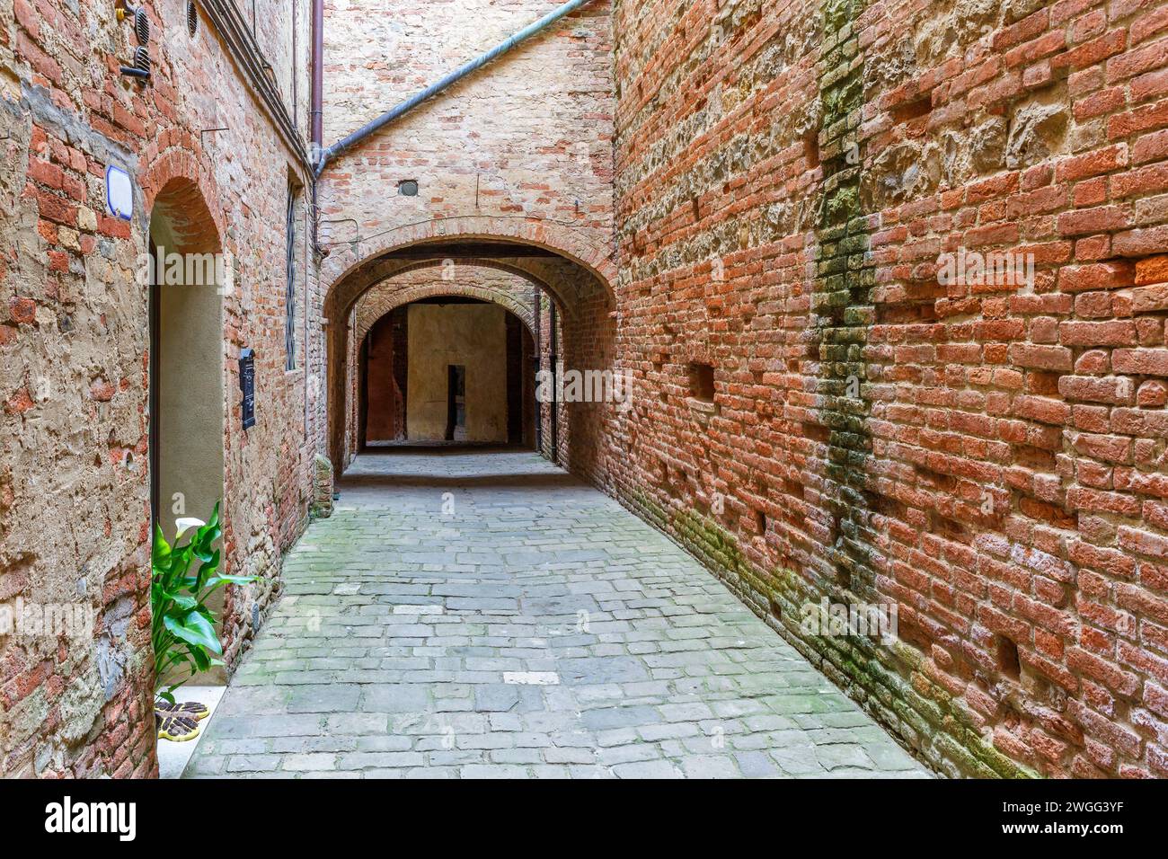 Alley with brick walls in an Italian village Stock Photo - Alamy