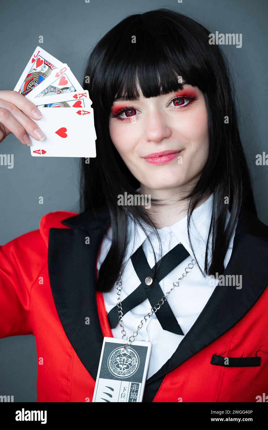 A female cosplay character with black hair, red eyes, a red jacket, and ...