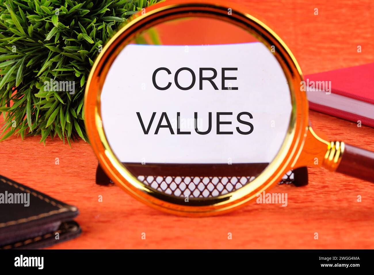 CORE VALUES word written on a business card through a magnifying glass ...
