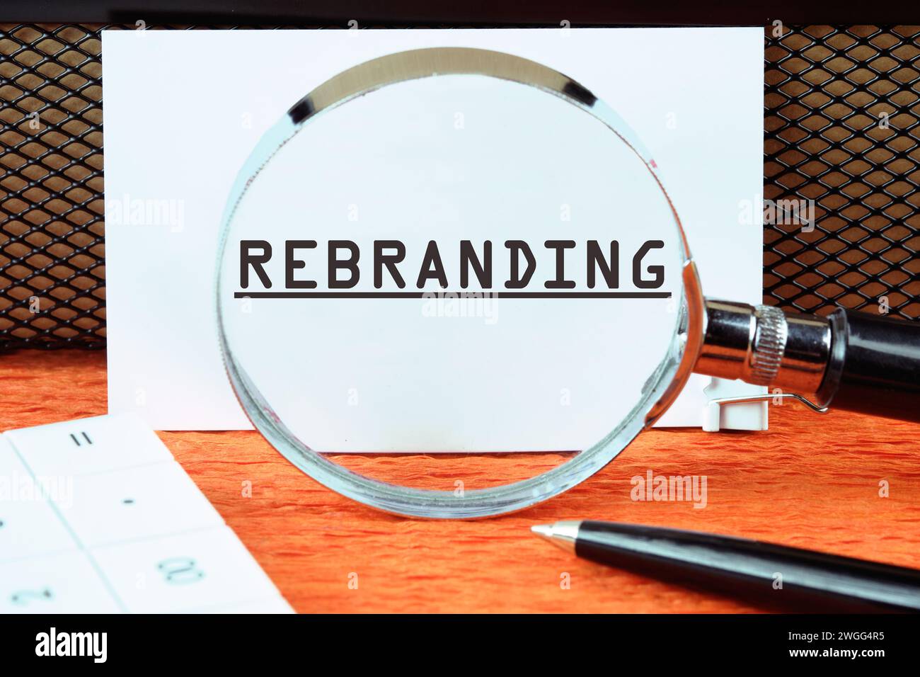 rebranding word written on a white card through a magnifying glass ...