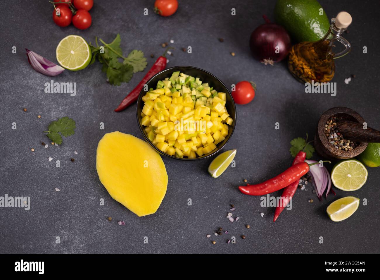 Cooking mango salsa - sliced chopped ingredients in a black ceramic ...