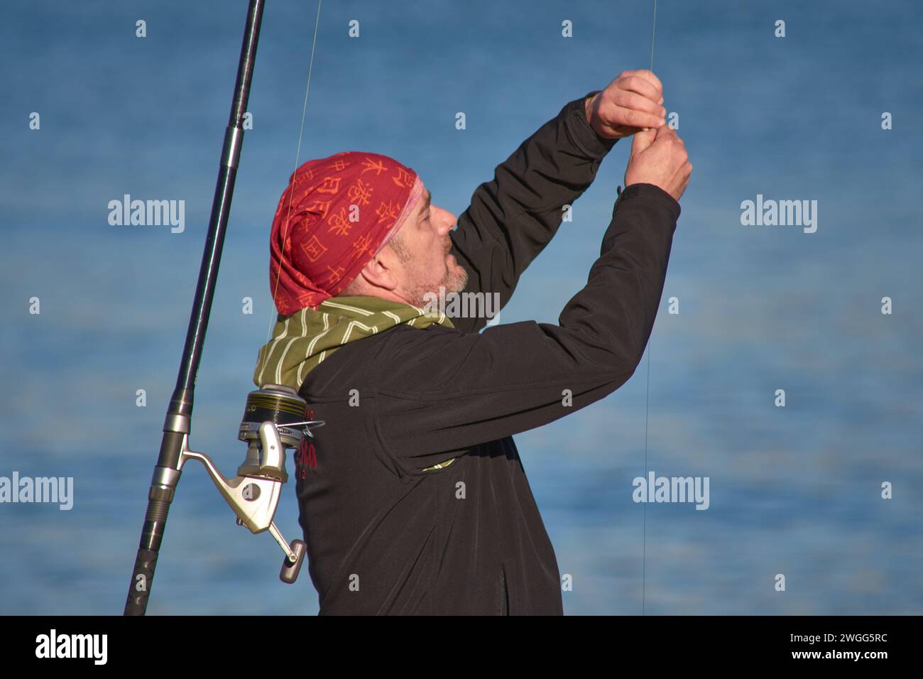 Baiona, Spain; July,14,2021: Angler with a red hat and his rod stuck in ...