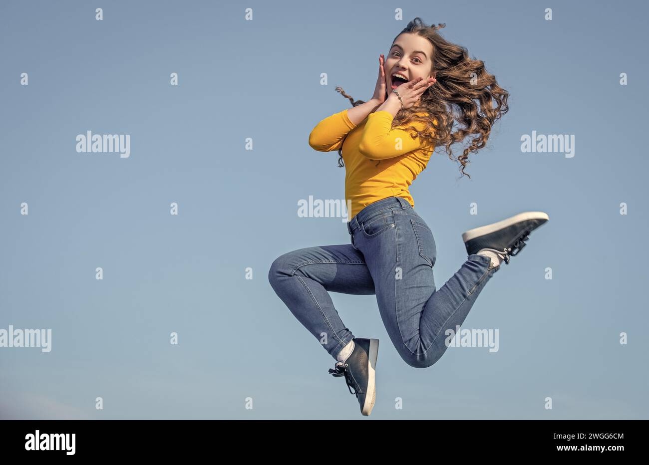 surprised teen girl jump high on sky background Stock Photo - Alamy