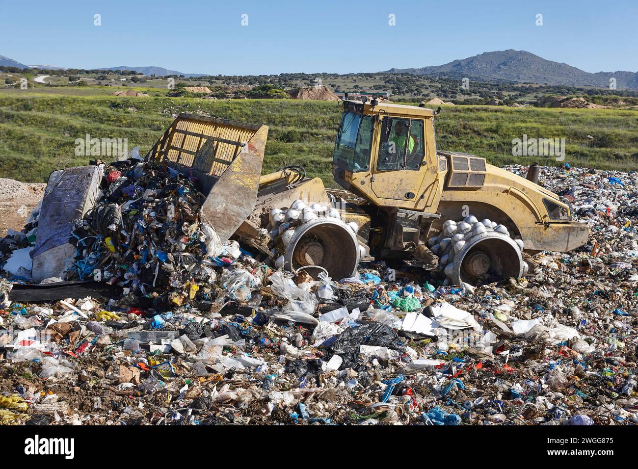 Heavy machinery shredding garbage in an open air landfill. Waste Stock ...