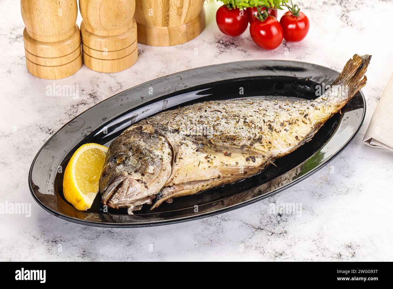 Baked Dorado fish served lemon slice Stock Photo - Alamy
