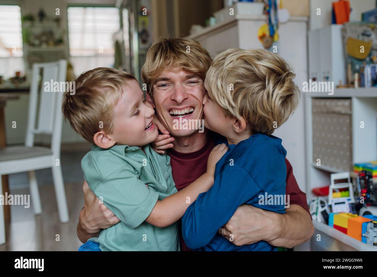 Two sons kissing father's cheeks. Concept of Father's Day, and fatherly ...