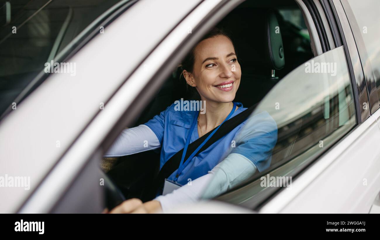 Female nurse sitting in car, going home from work. Female doctor ...
