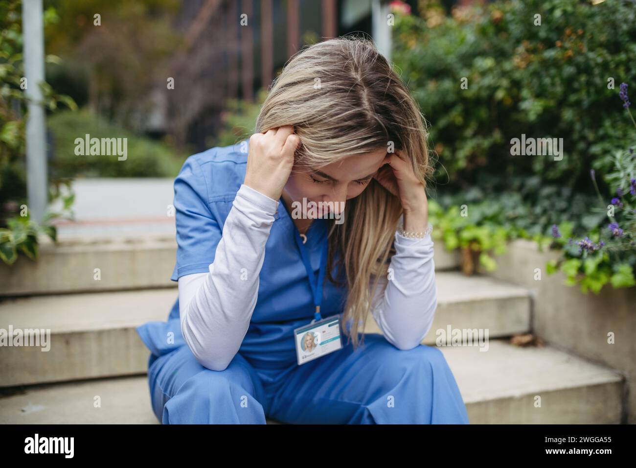 Female doctor feeling overwhelmed at work, sitting on stairs ...