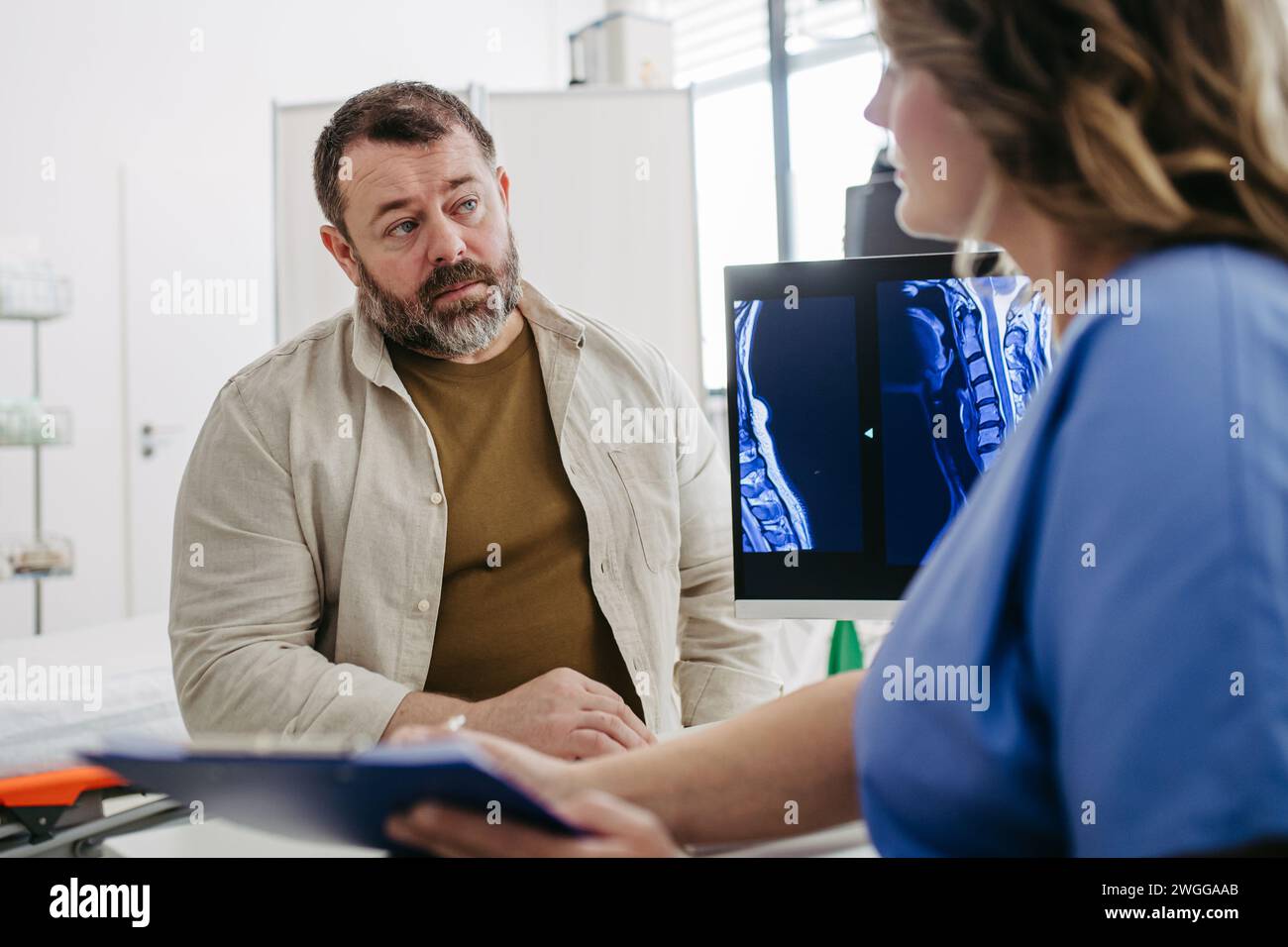 Doctor consulting with overweight patient, discussing test result and x ...
