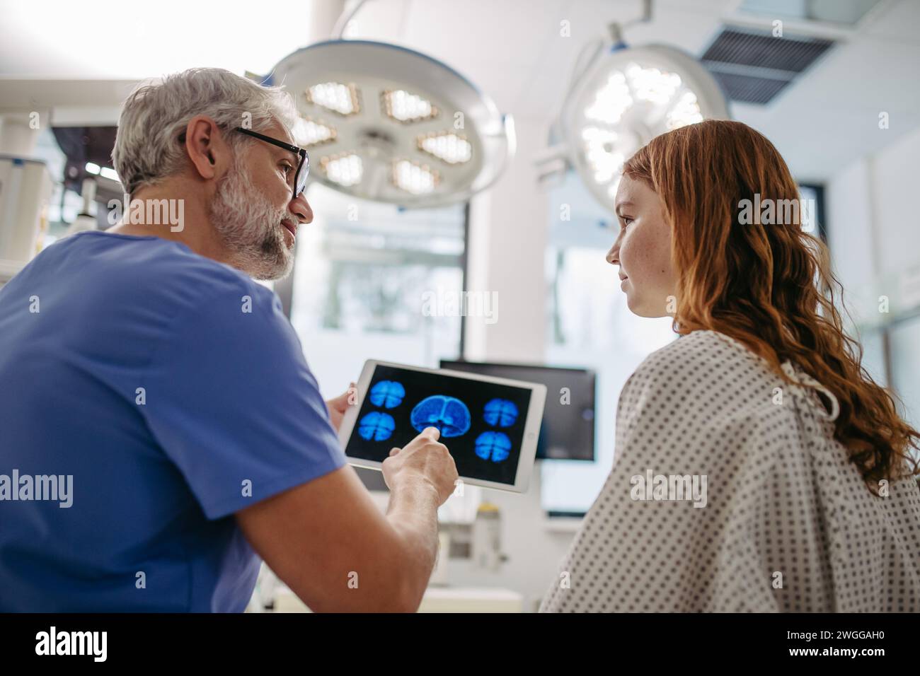 Doctor showing teenage patient MRI scan on tablet, discussing test ...