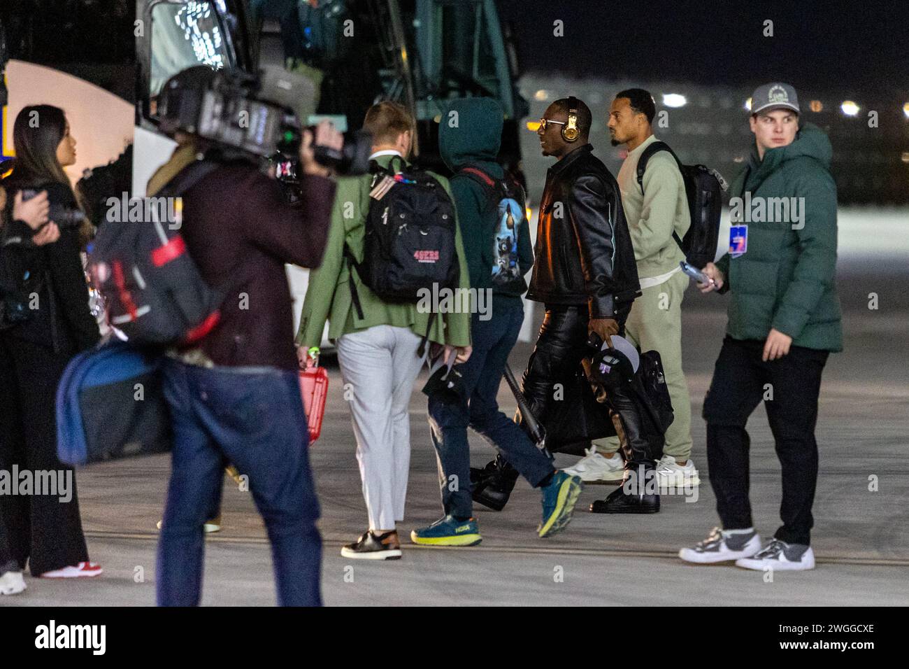 The San Francisco 49ers walk along the tarmac to team busses during ...