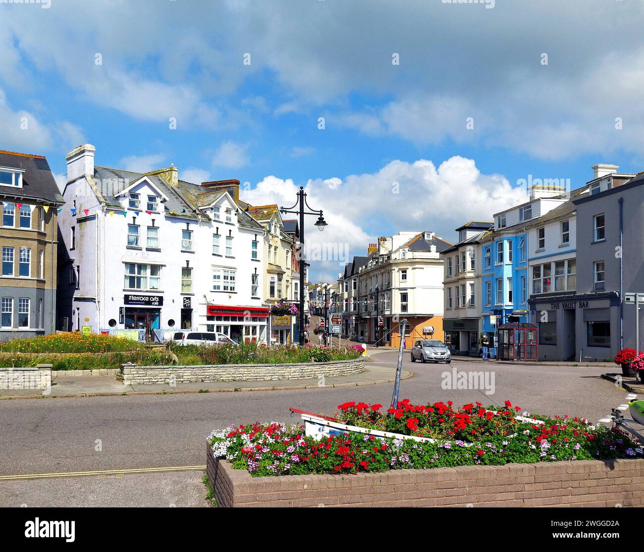 View of Fore Street shops in the town centre with pretty flowerbeds in ...