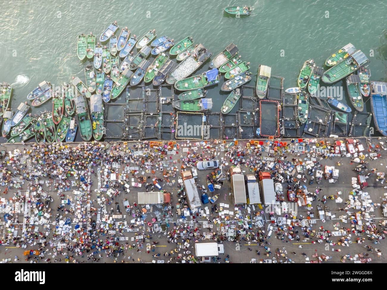 Aerial photo shows the bustling seafood market at a fishing port wharf ...