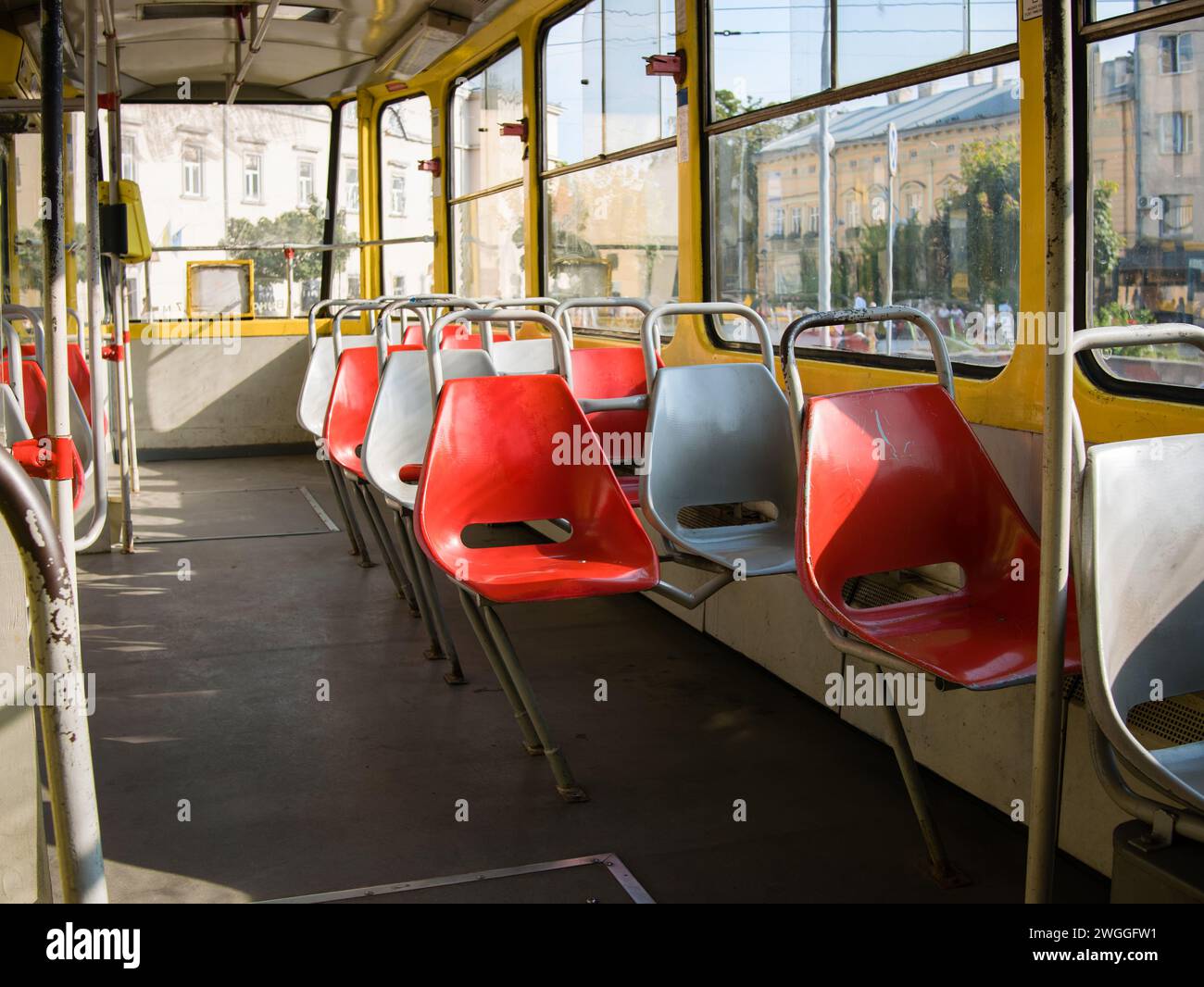 Seats for passengers in an empty carriage of an old tram on a sunny day ...
