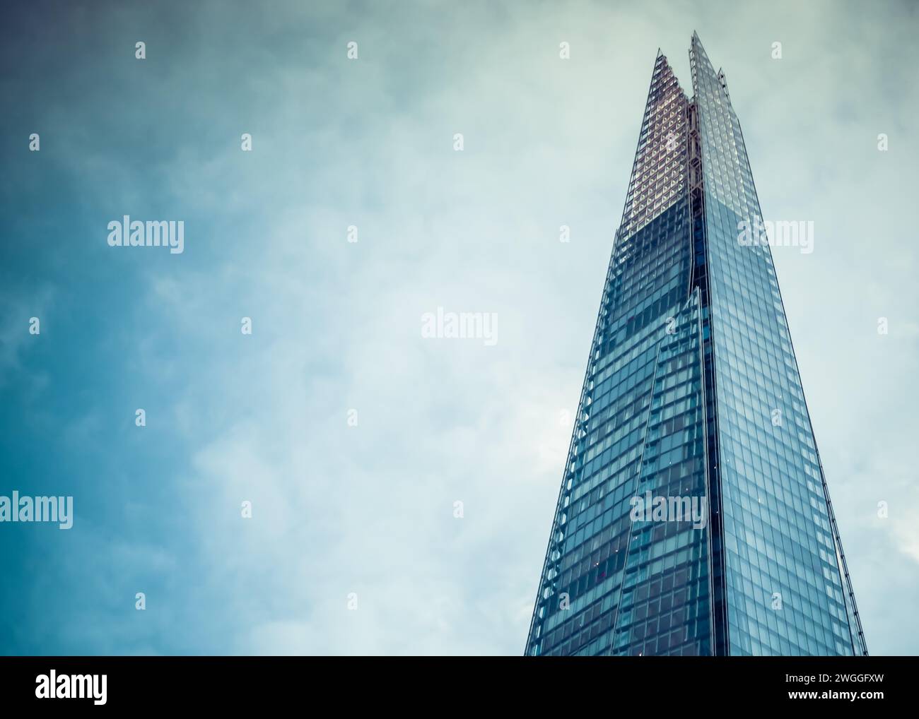 Tall skyscraper reaching into blue and gray skies Stock Photo - Alamy