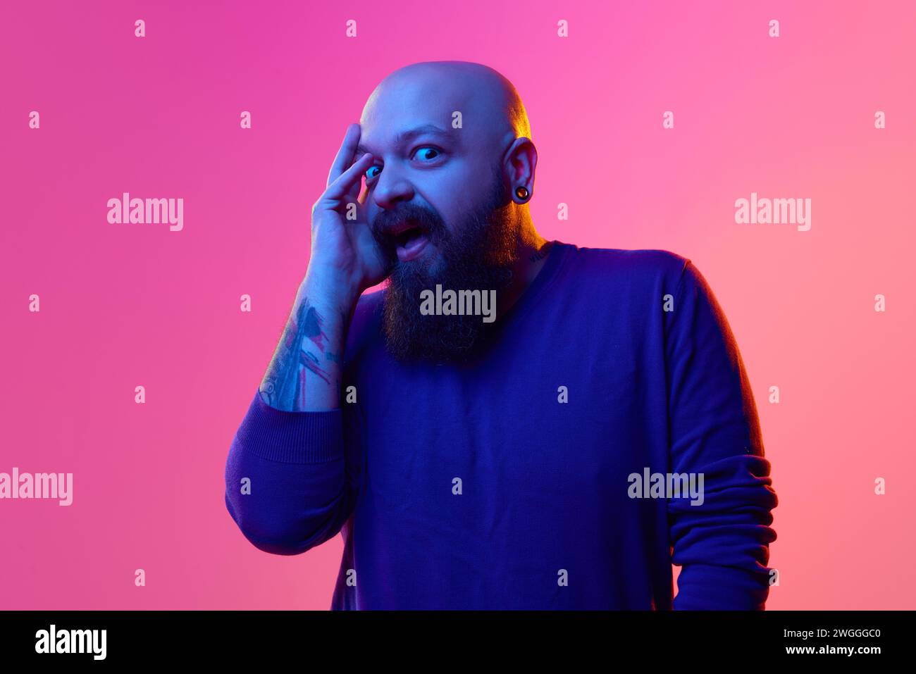 Portrait of emotive bald bearded man in his 30s expressing shocked face, emotions against pink ...