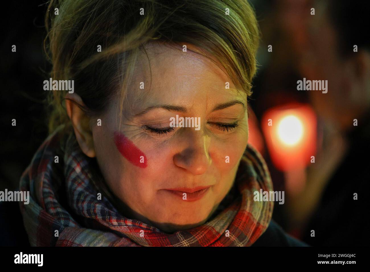 A woman with a red mark on her face, during a torchlight procession for ...