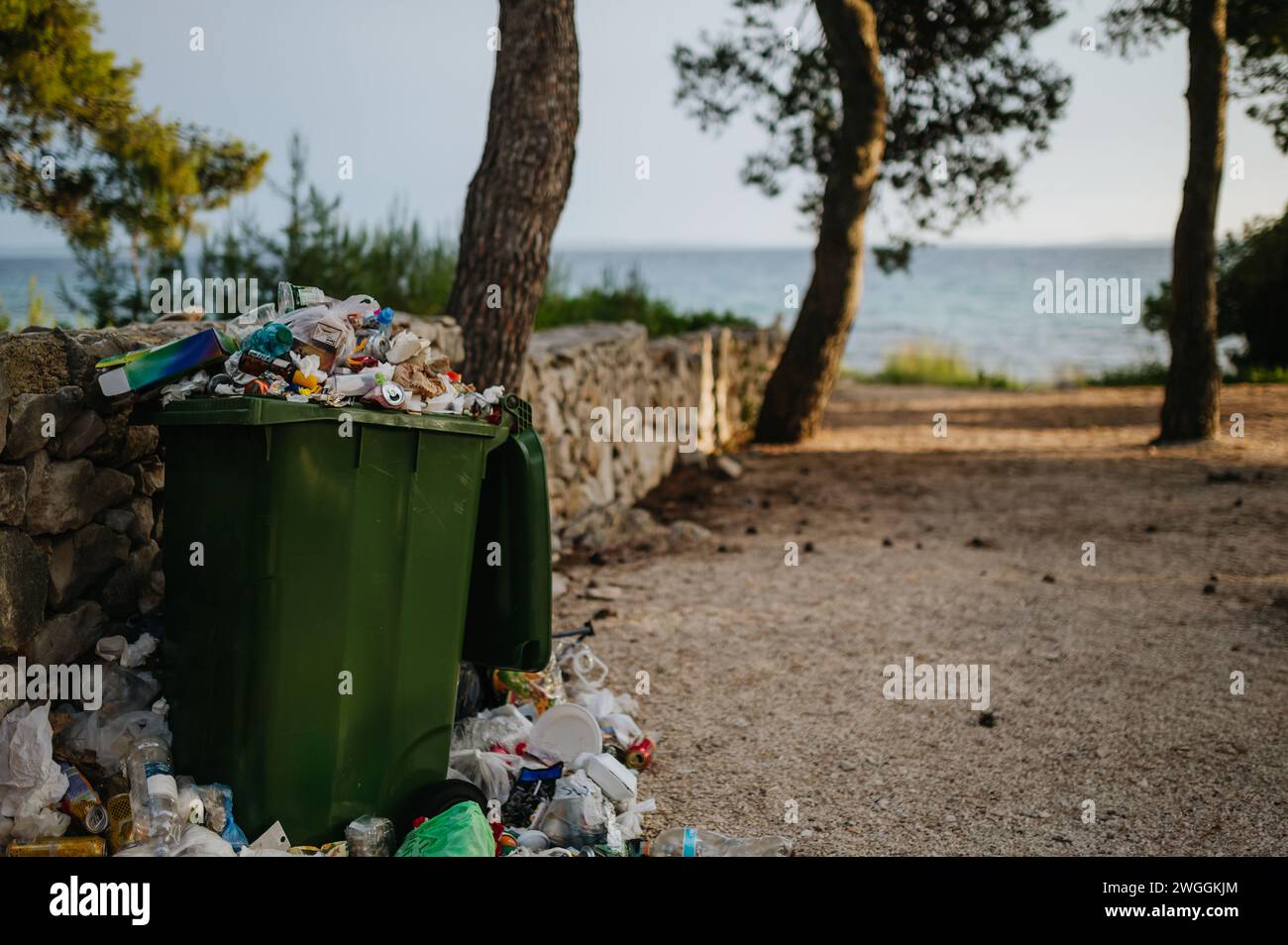 Trash in the street spilling on to the pavement. Full bins in holiday ...