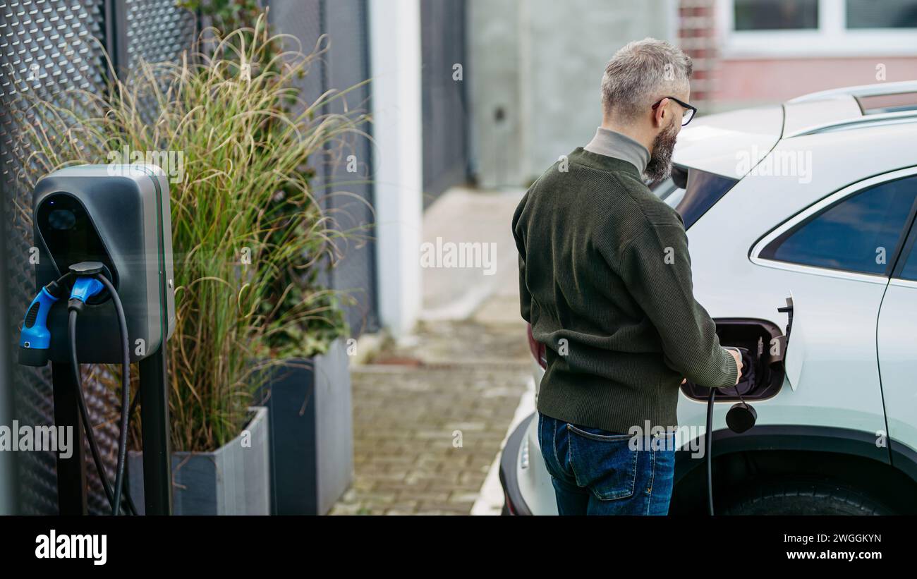 Businessman charging electric car before going to office. An electric ...