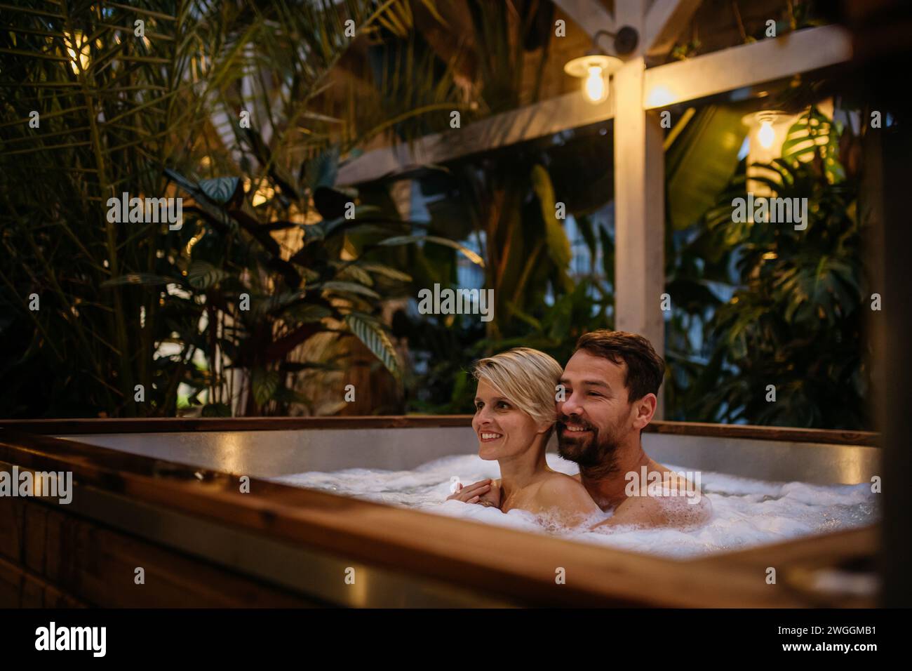 Beautiful mature couple relaxing in hot tub, enjoying romantic wellness ...