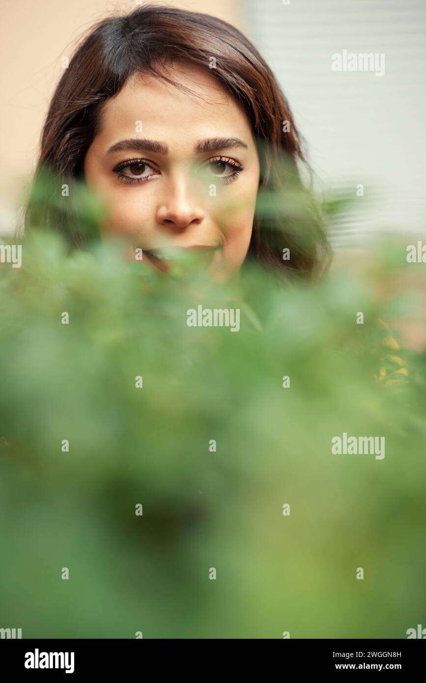 Woman peeking through plants hi-res stock photography and images - Alamy
