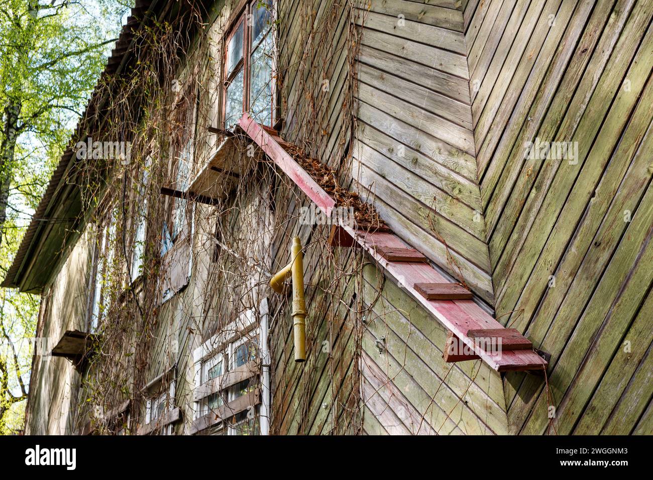 Wall of an old two-story house with a cat ladder leading to the second ...