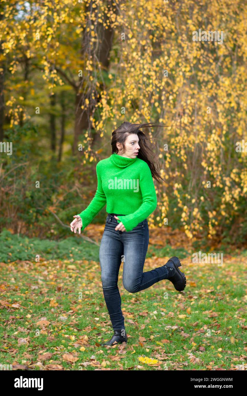 Woman running in the forest in fear Stock Photo - Alamy