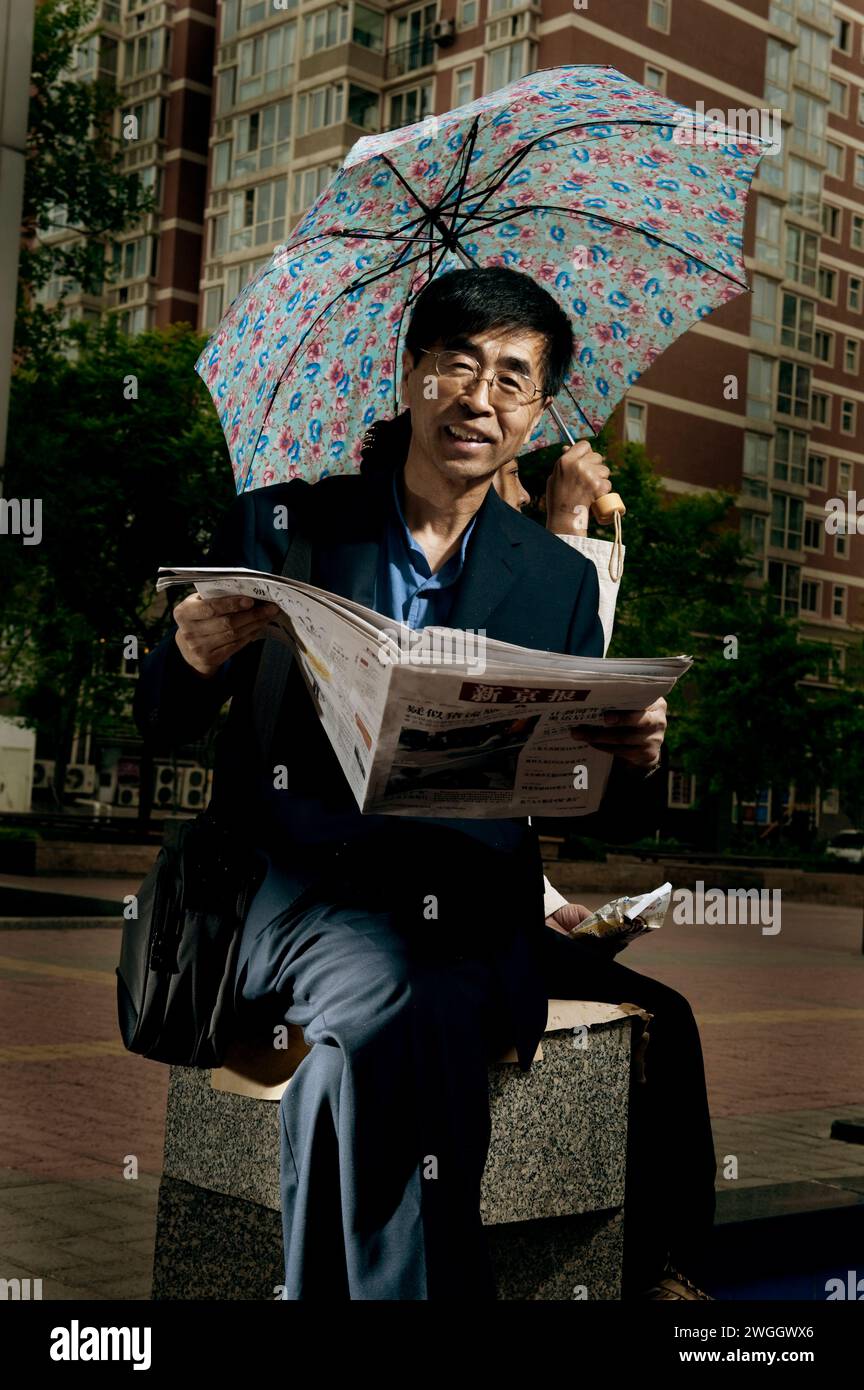 A chinese man reading a newspaper Stock Photo - Alamy