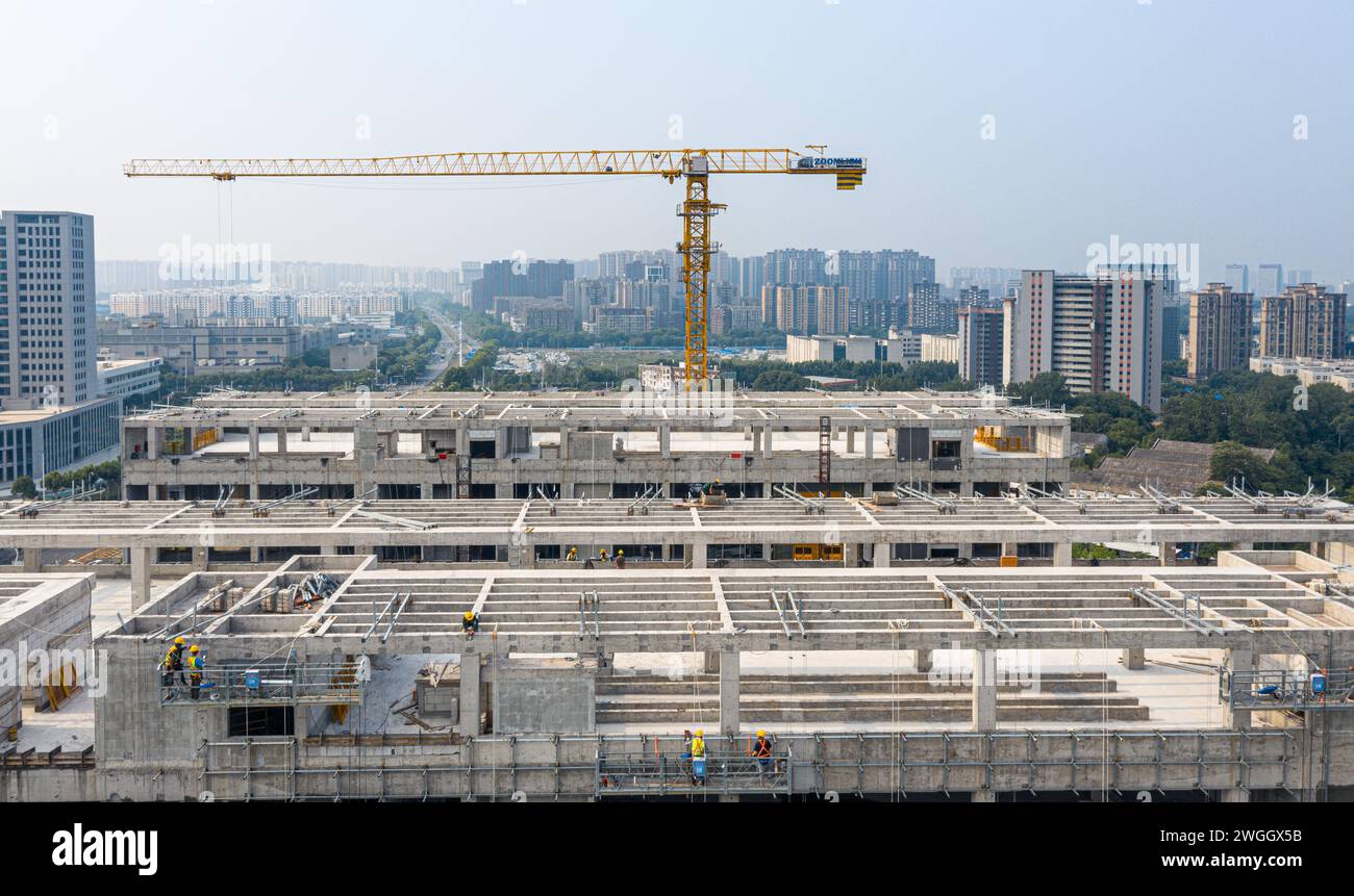 Two construction cranes on top of a high-rise apartment building ...