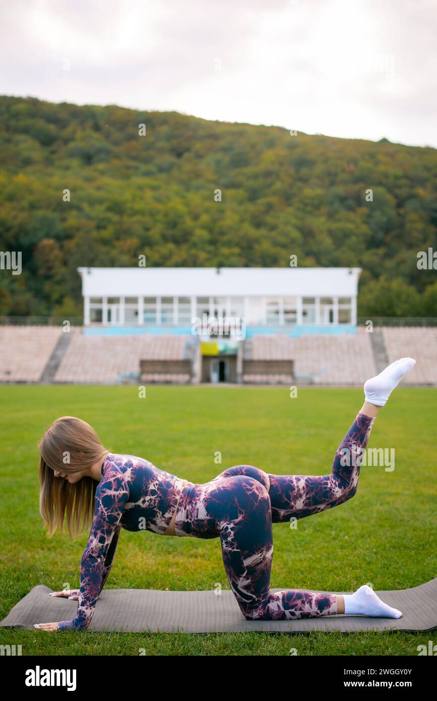 Photo of fit girl doing exercises on stadium in sportswear on stadium ...