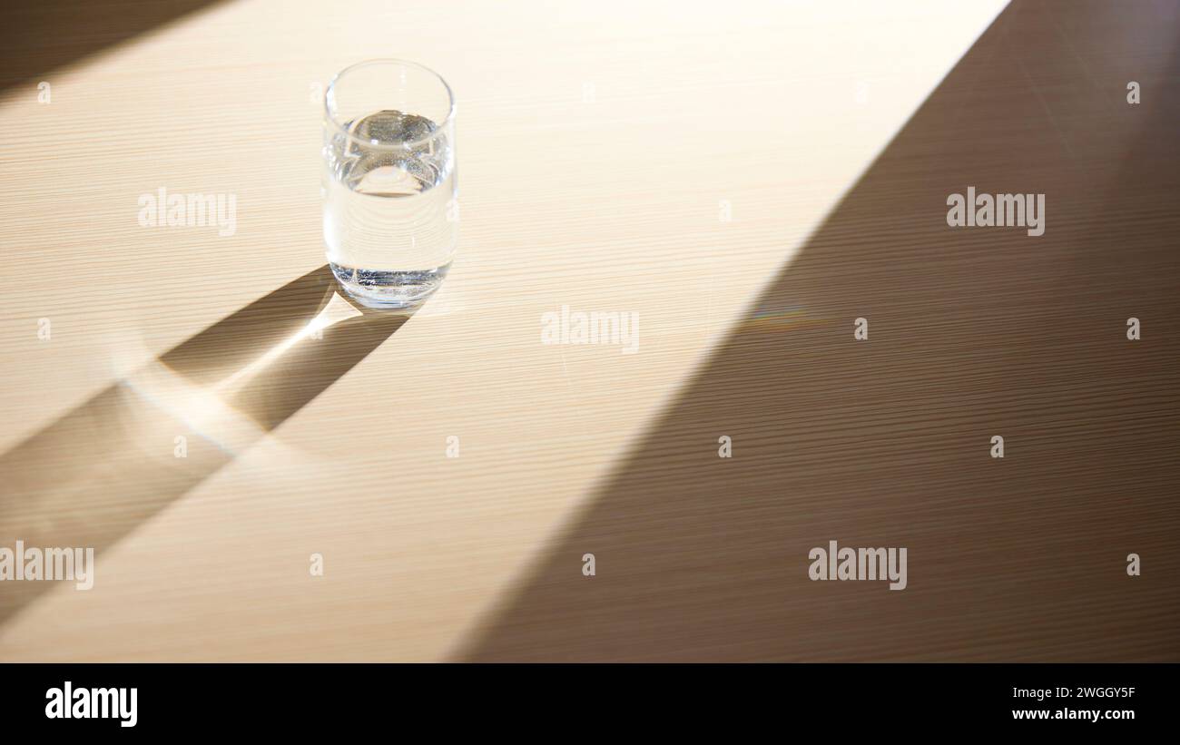A water cup and shadow on a table in the sunlight Stock Photo - Alamy