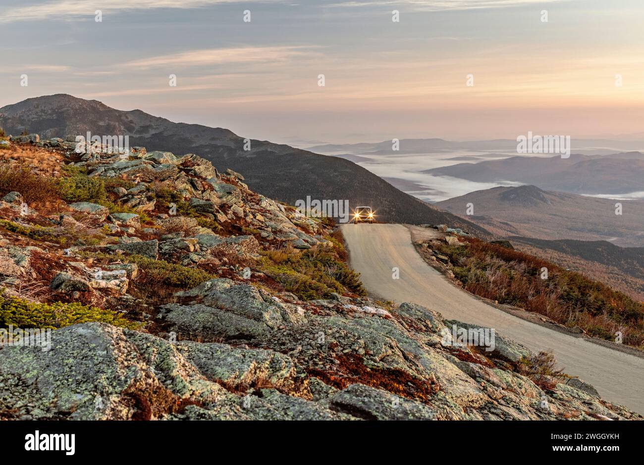 Car with headlights on drives up Mount Washington auto road Stock Photo ...