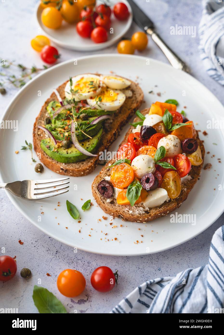 Close up plate of toast with avocado, egg, tomatoes, mozzarella Stock ...
