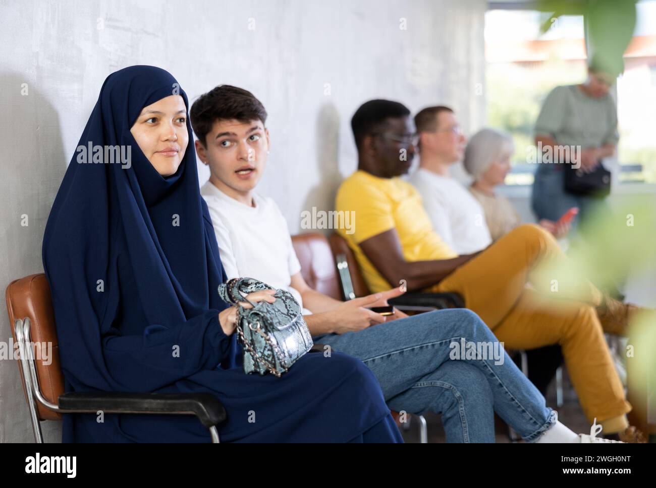 Young arab woman waiting in line at reception Stock Photo - Alamy