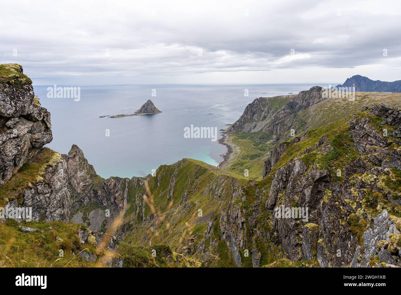 Rocky mountain with water in the distance and rocks on the ground below ...