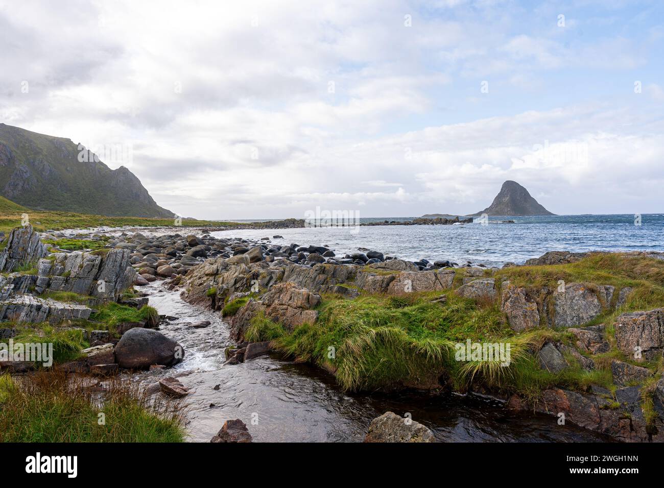 River flowing between rocky areas with mountains in the background ...