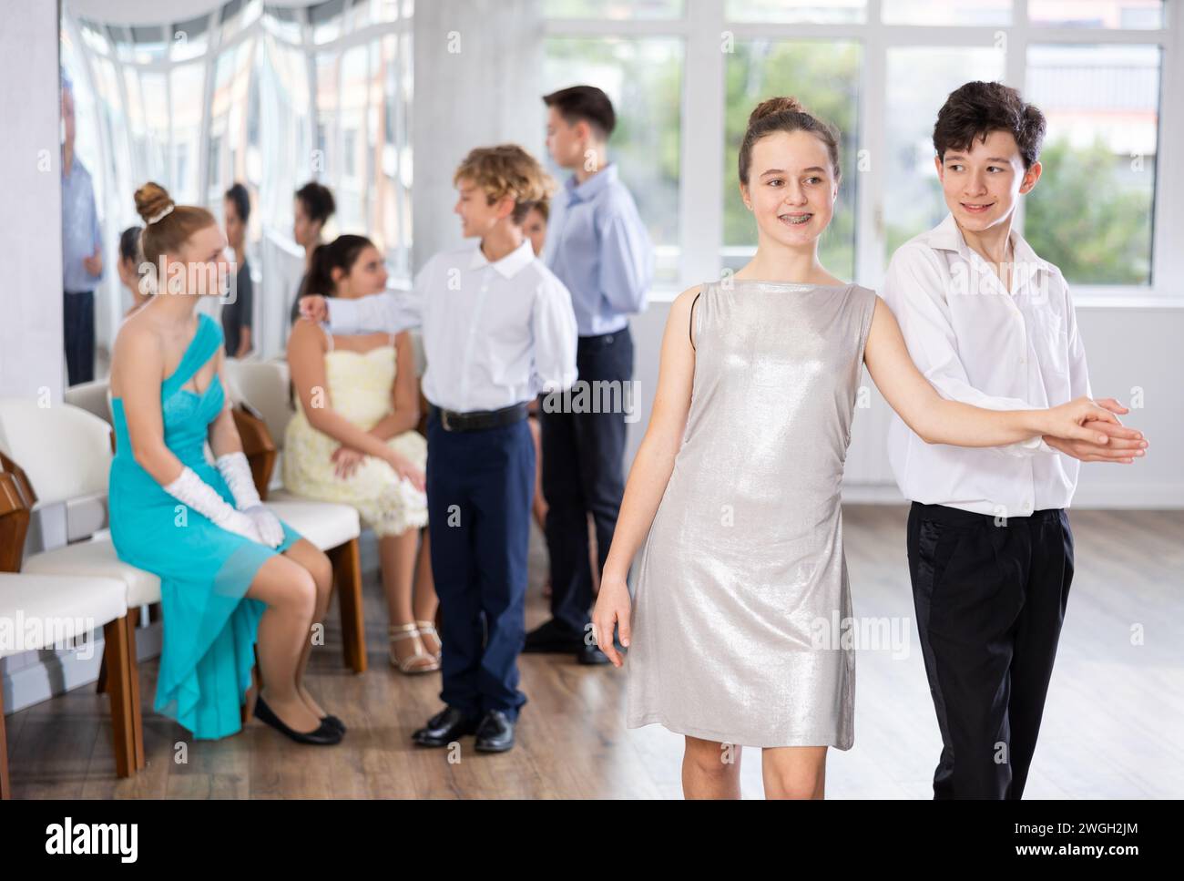 Enthusiastic teenagers performing waltz during group dance lesson Stock ...