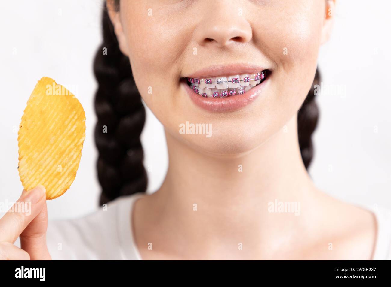 Close-up of young smiling woman refusing holds potato chips. Concept of ...