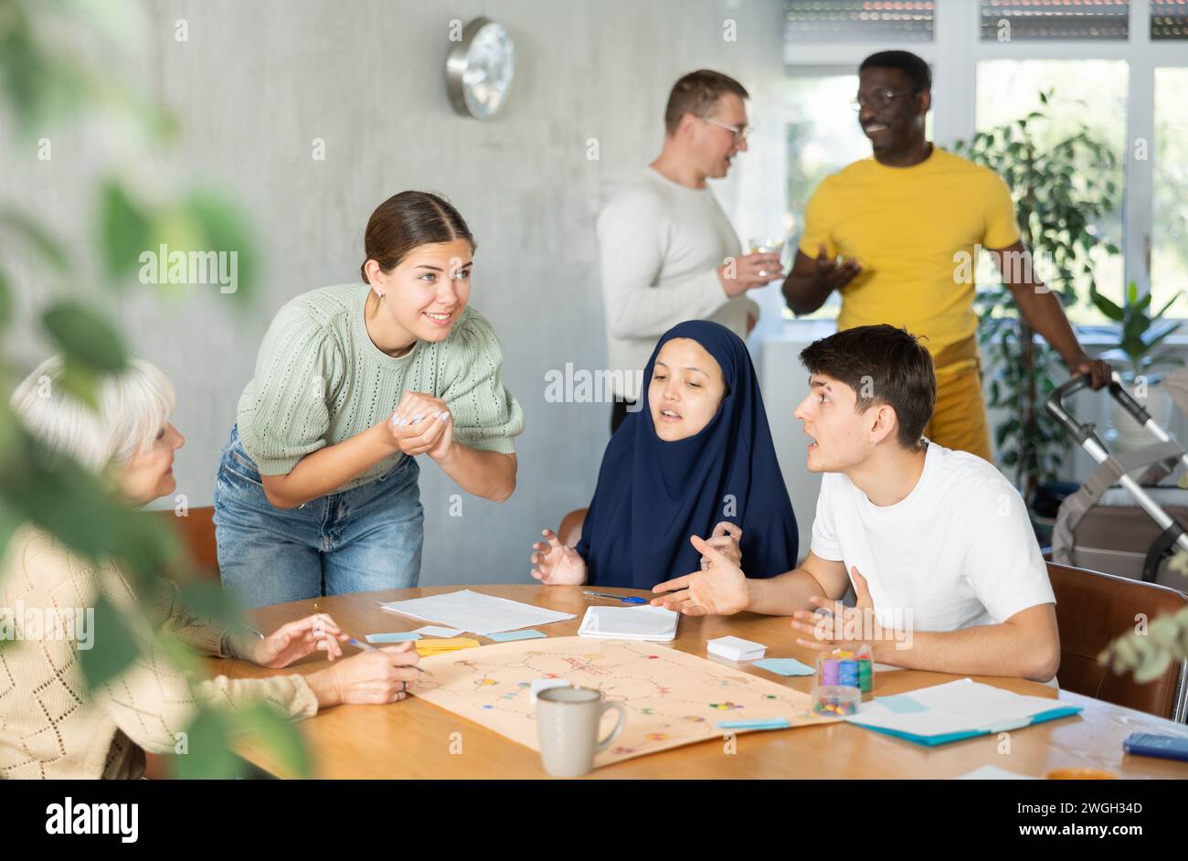 Group of multinational people playing board game Stock Photo - Alamy