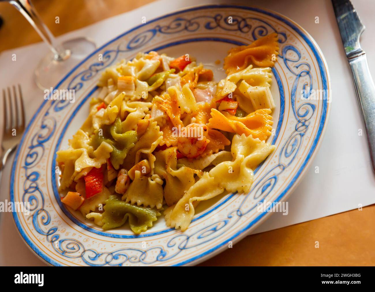 Spanish cuisine seafood pasta with fish and prawns served at plate ...