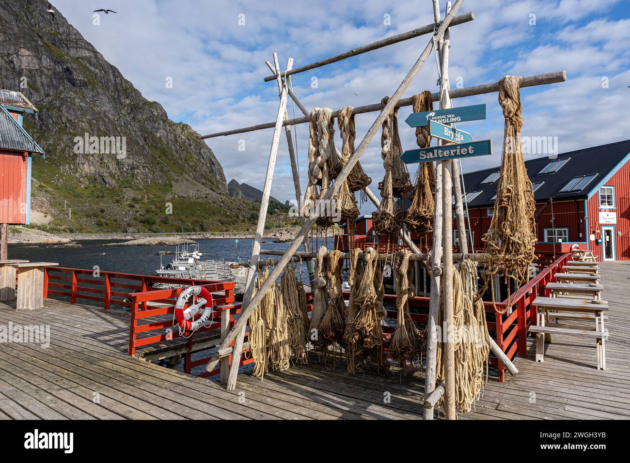 A scenic dock with a variety of objects and vibrant red boats floating ...