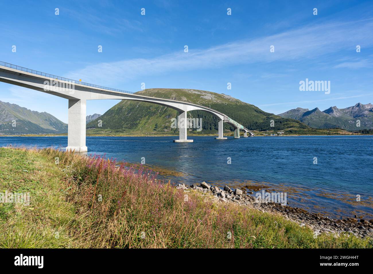 A vast Norwegian bridge extends over a serene lake, seamlessly ...