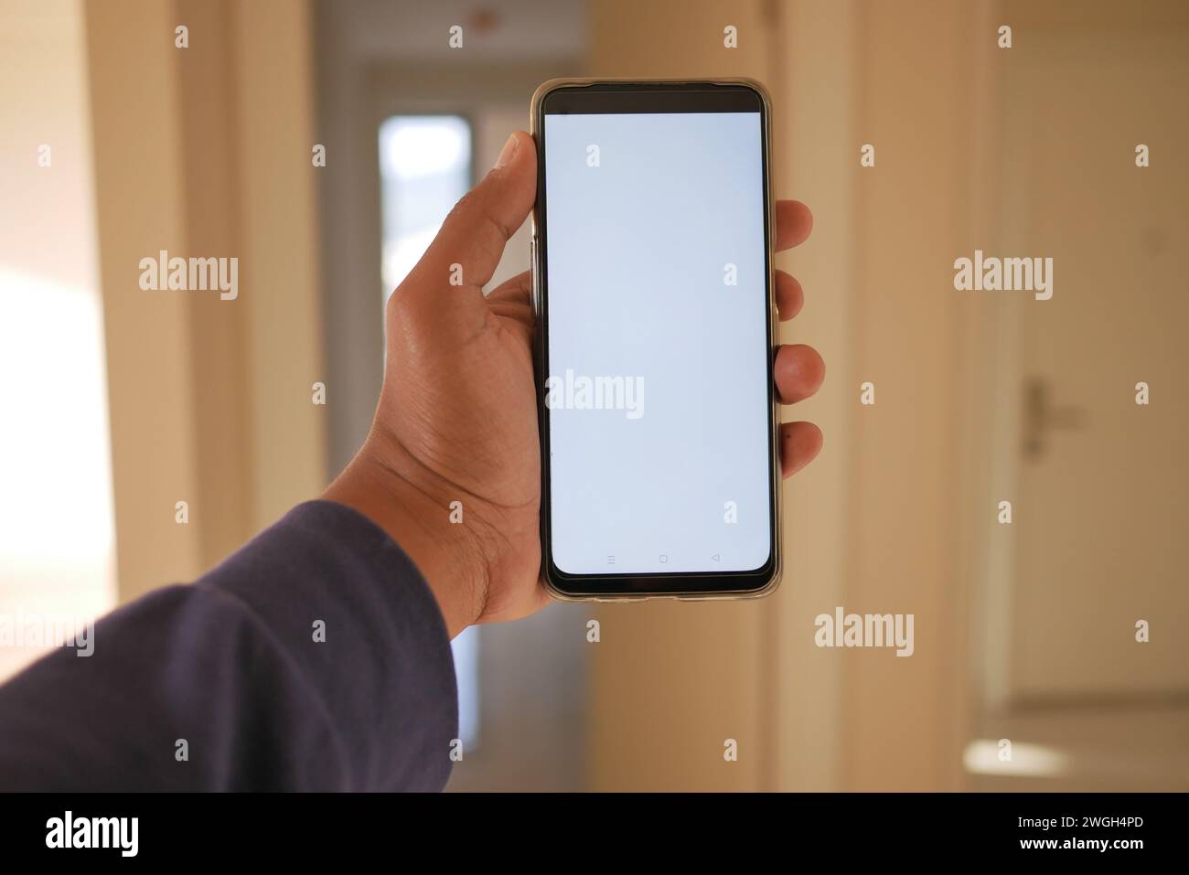 close-up hand using phone showing white screen in empty room Stock ...