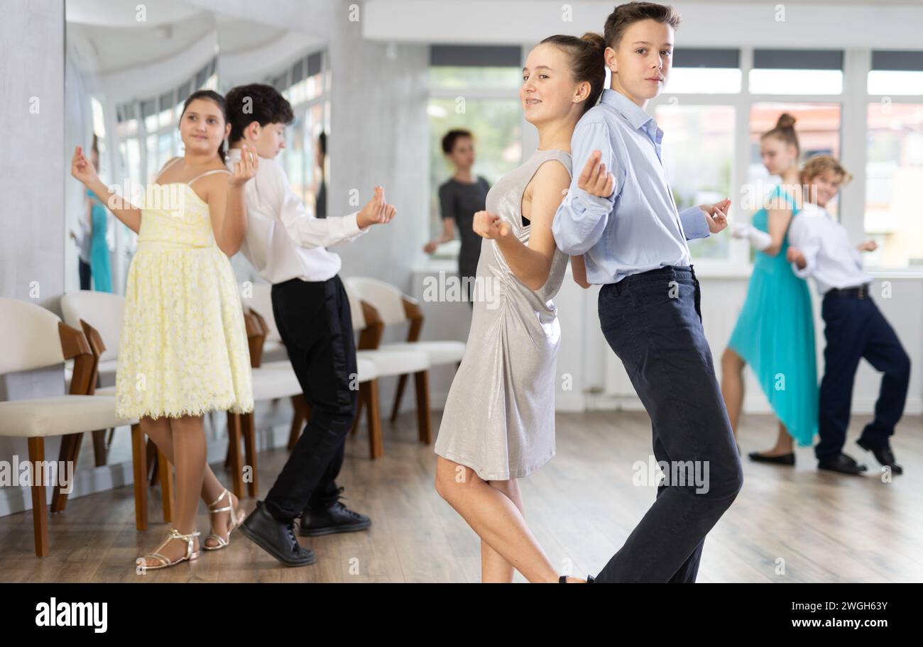 Teenagers standing back-to-back in pairs and snapping fingers during ...