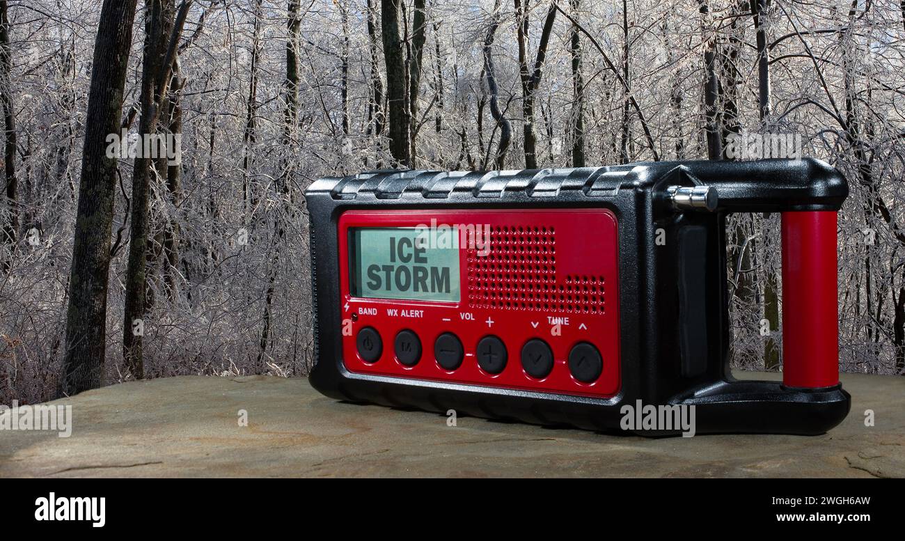 Forest covered in ice behind a battery powered weather radio with solar ...
