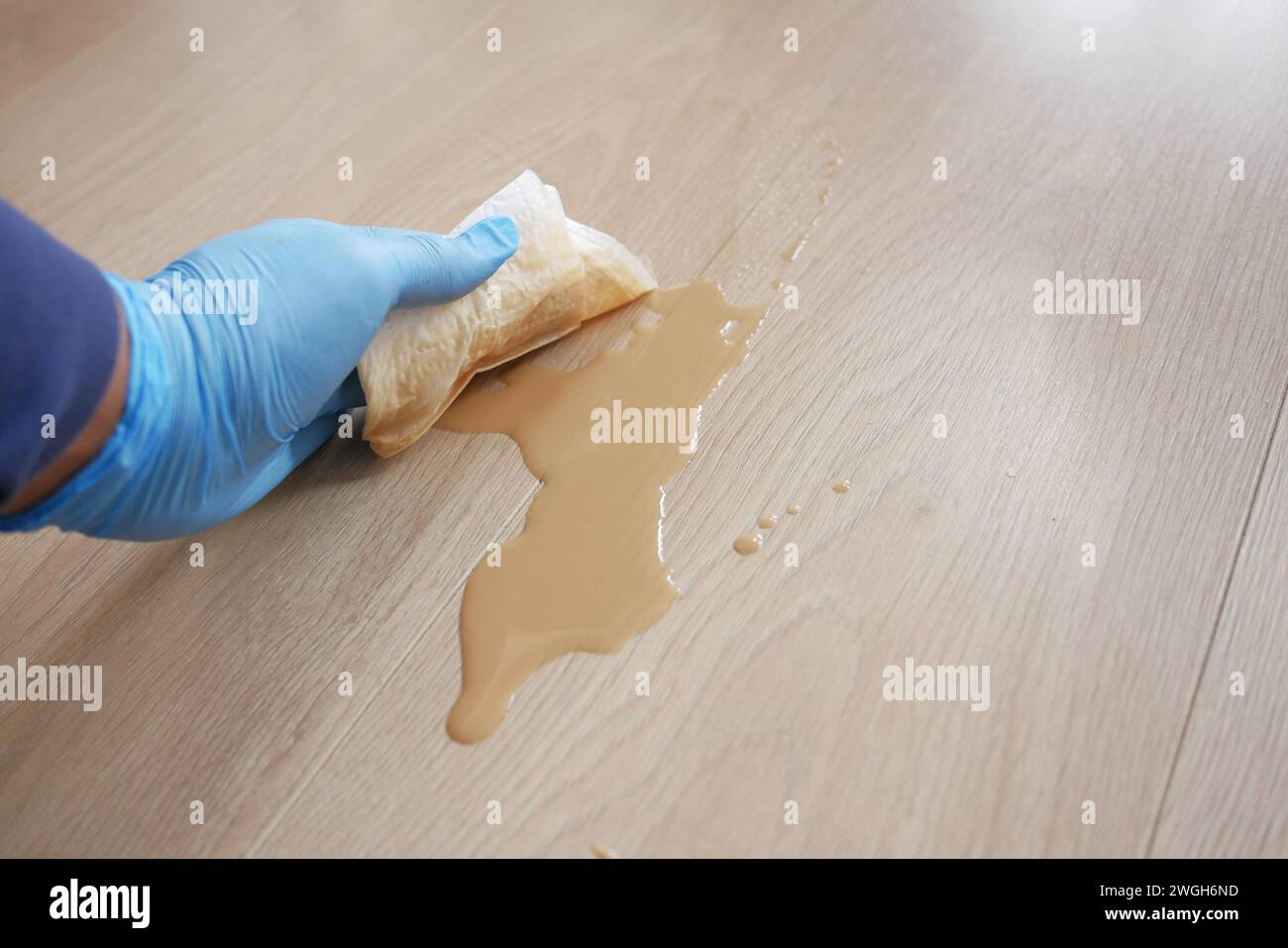 A man's hand washing the floor with a tissue Stock Photo - Alamy