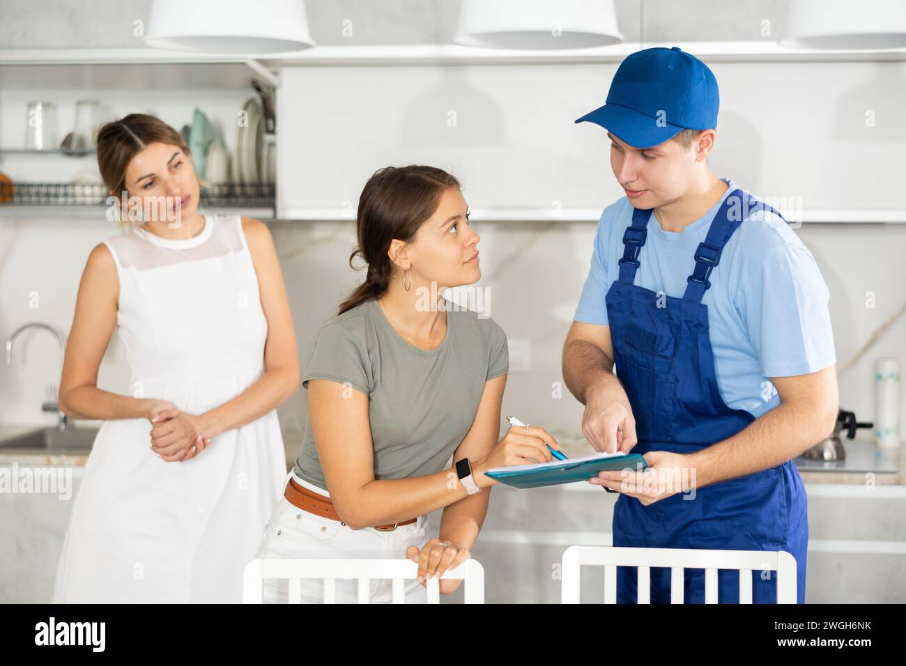 Guy employee of repair team in blue overalls submits to female client ...