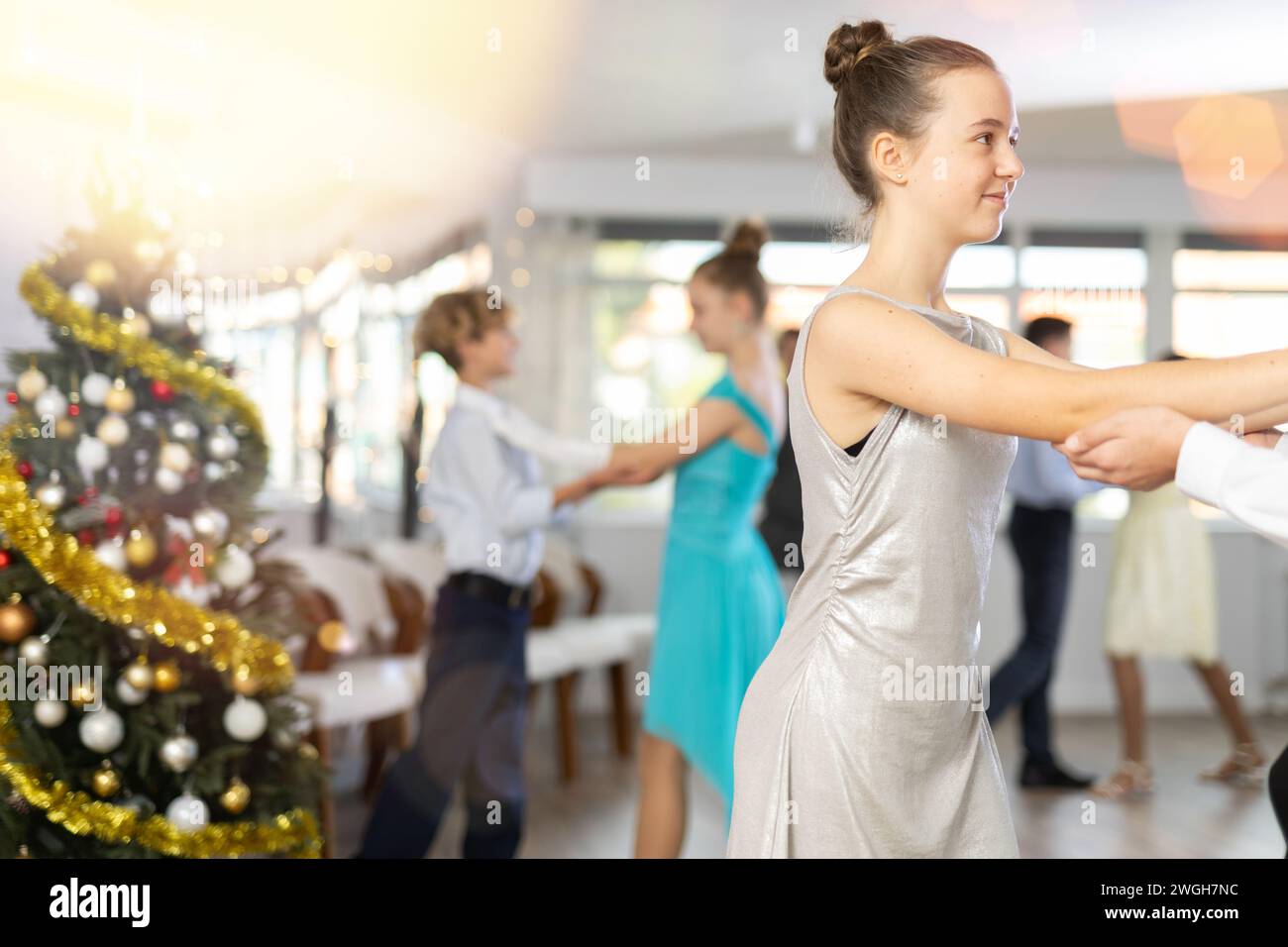 Teenage girl dancing waltz with classmate during Christmas party at ...