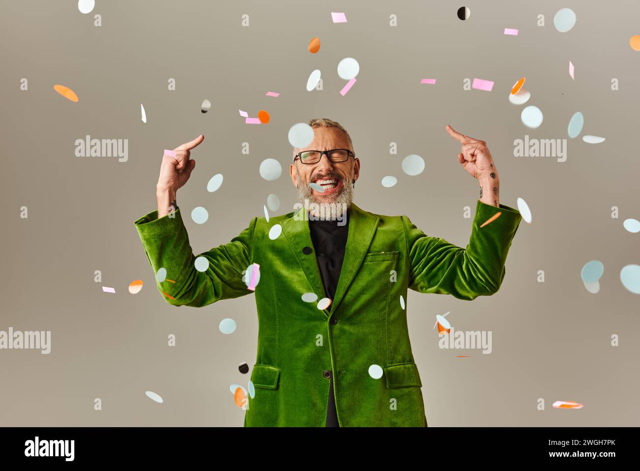cheeky jolly mature man with closed eyes in green blazer showing middle ...